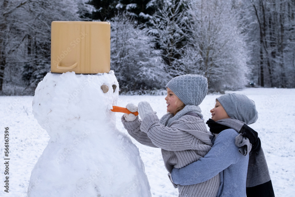 Brother and sister making snowman Stock Photo | Adobe Stock
