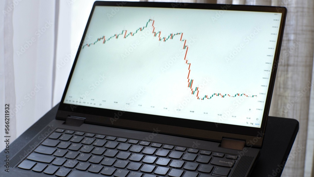 a bright screen of a laptop or computer showing a stock price chart ...