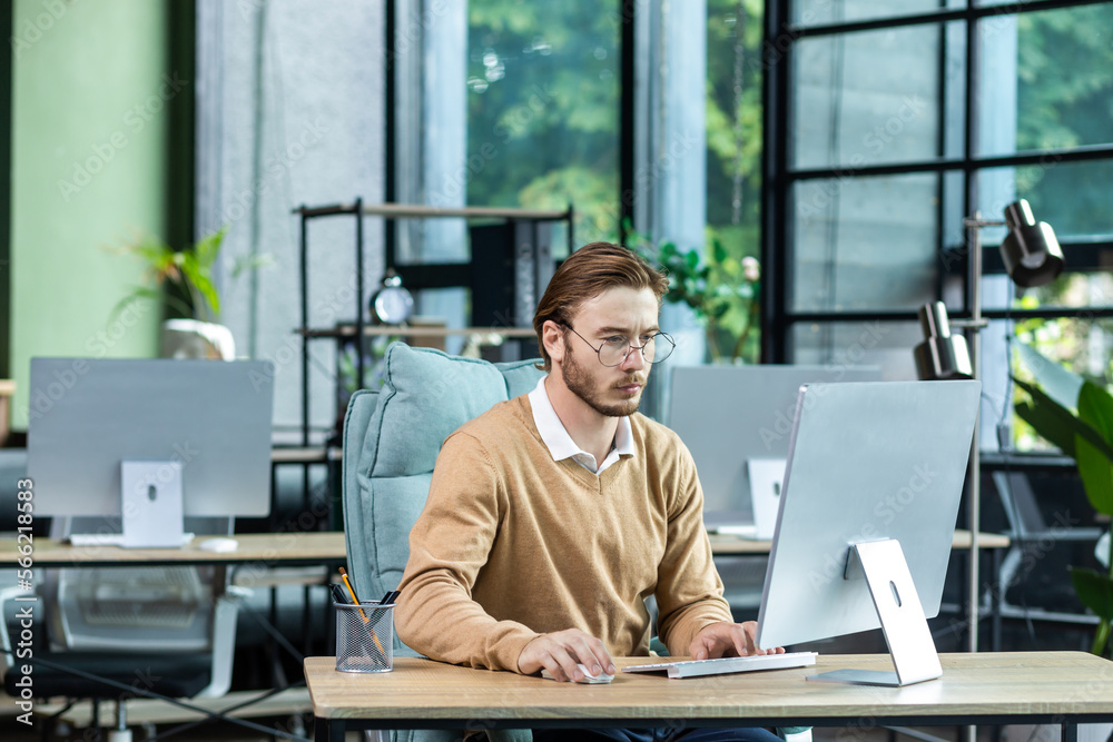 Serious and scorn-centered man in the office at work with a computer ...