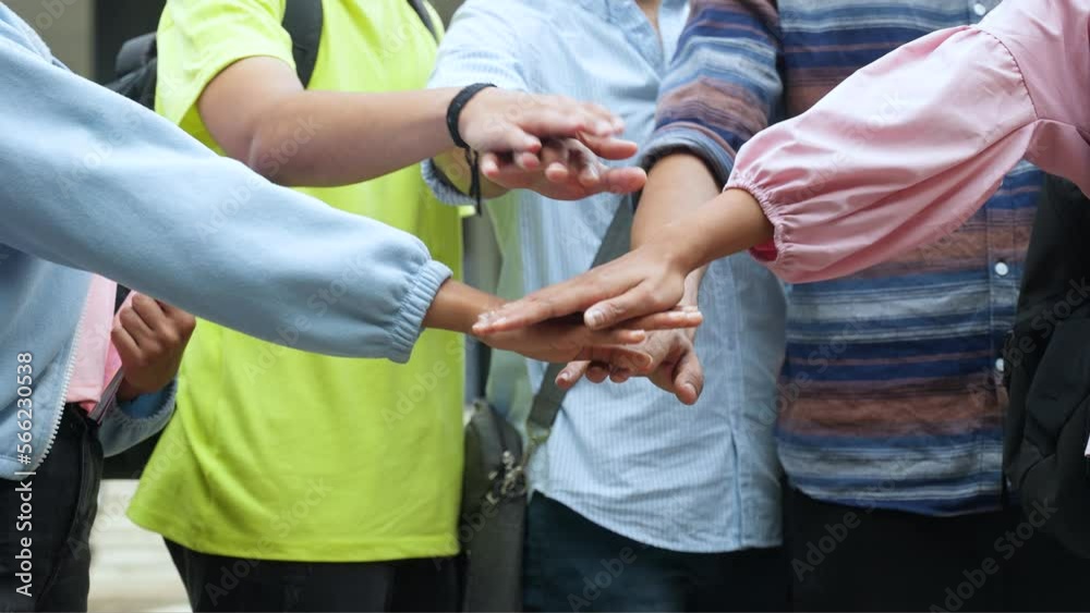 Close up shot group of students joining hands at college campus for ...