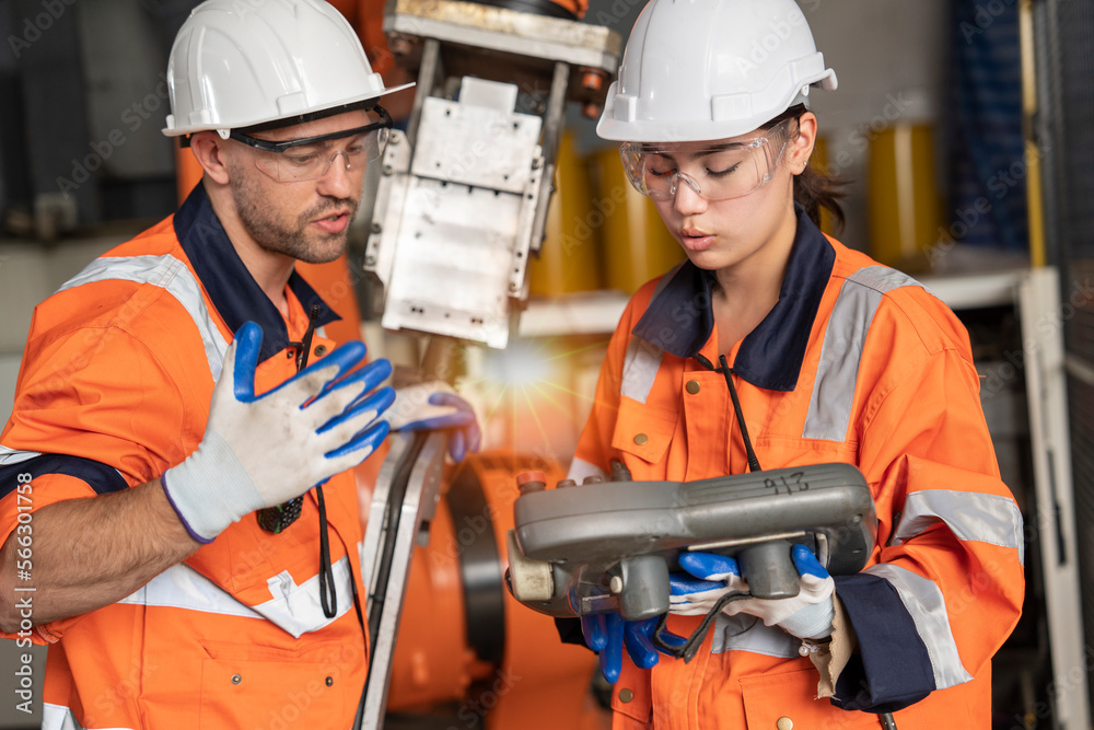 Asian male engineer and female programmer examining the operation of a ...