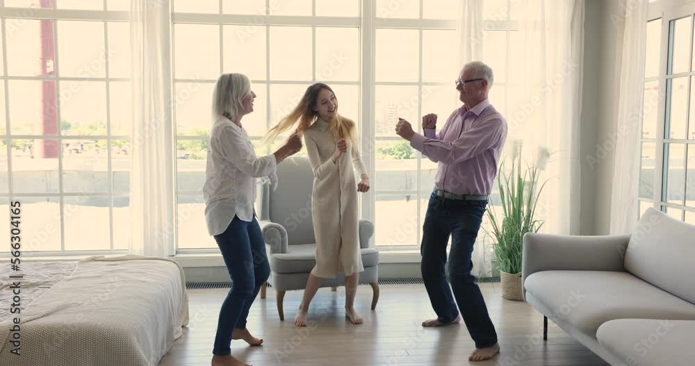 Happy multi generational family dance in living room, lively moving to ...