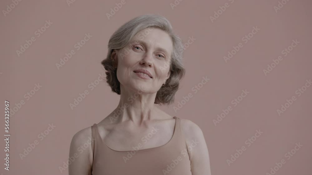 Portrait of beautiful 60s grey-haired mature senior adult female posing ...