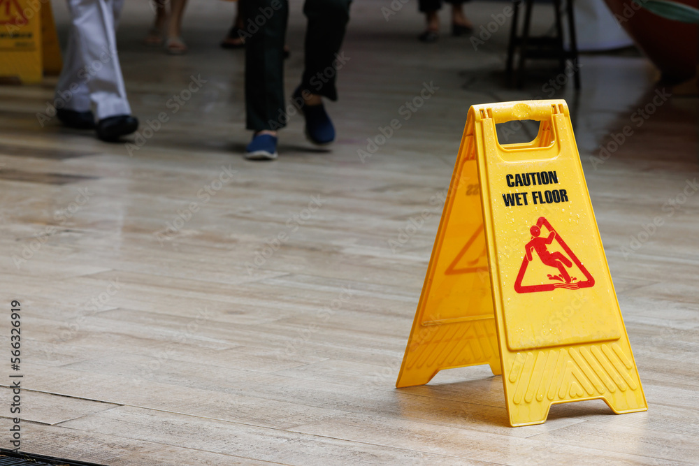 wet floor sign with water drops on wet stone floor. plastic sign ...