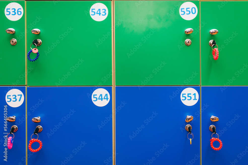 Blue and green lockers with keys and numbers in a public locker room in ...