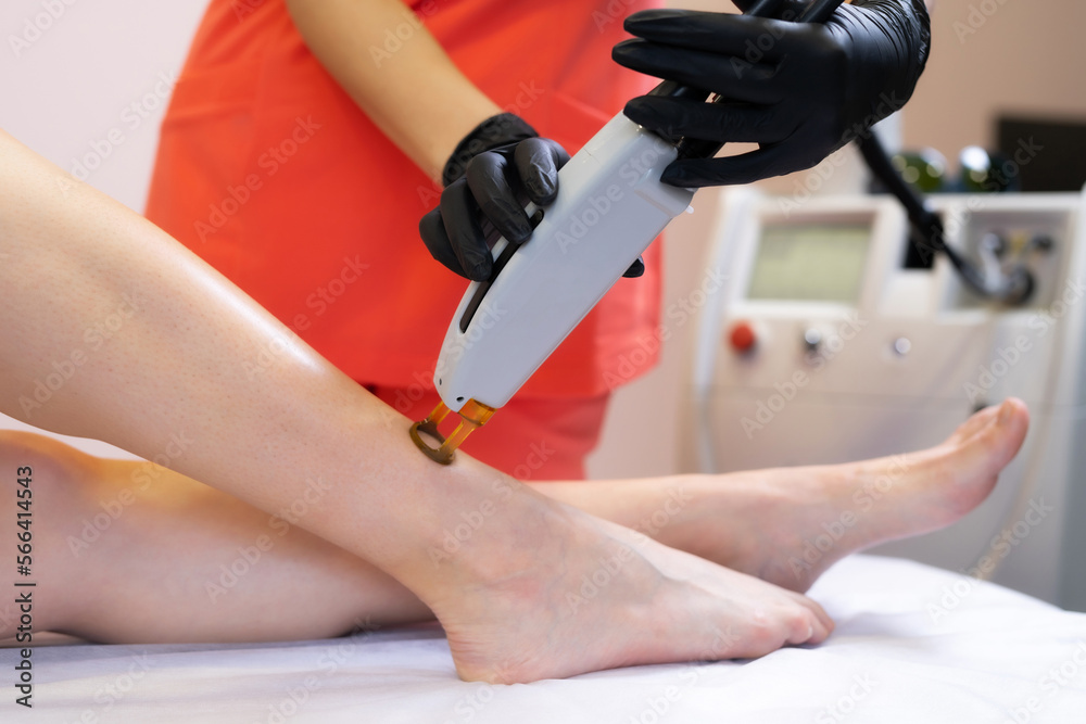the process of hardware laser hair removal on the legs in a beauty ...