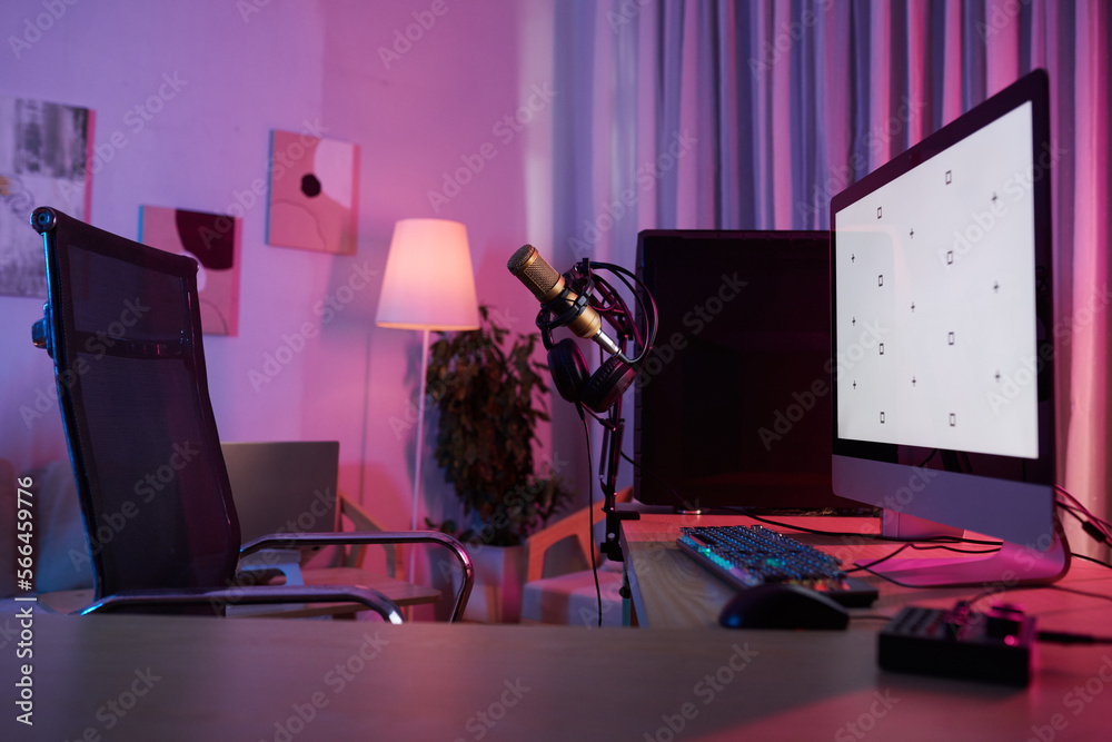 Professional microphone, computer monitor and keyboard on desk of gamer ...