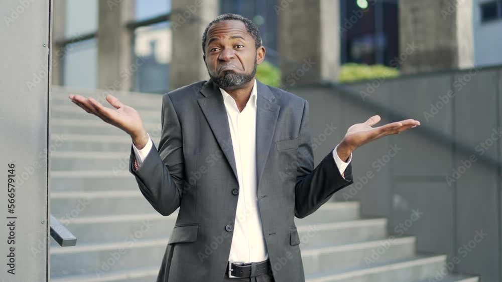 Surprised puzzled african american mature man spreads his hands, shrugs ...