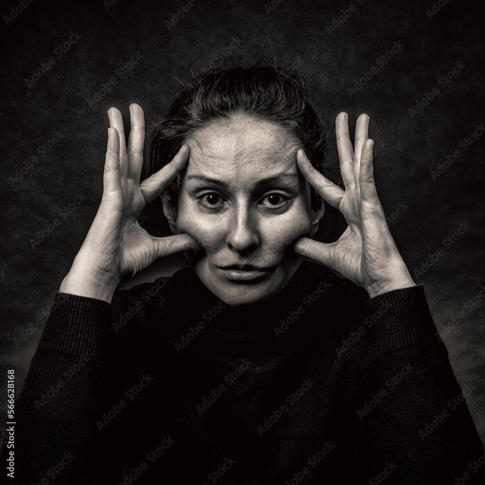 Foto de Conceptual dark portrait of woman stretching the skin of her ...