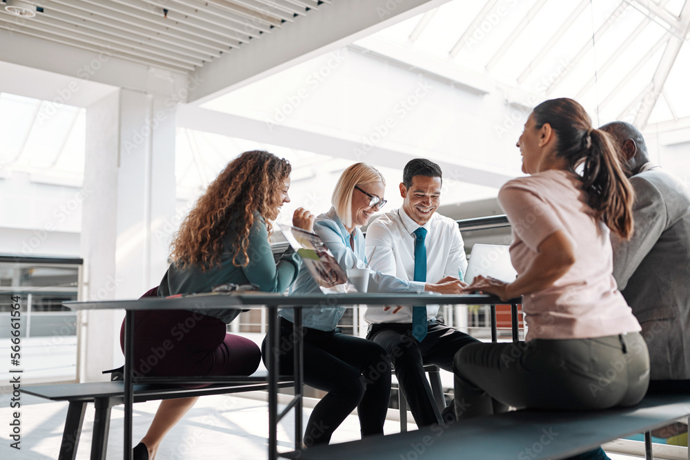Laughing businesspeople talking around a table in an office Stock Photo ...