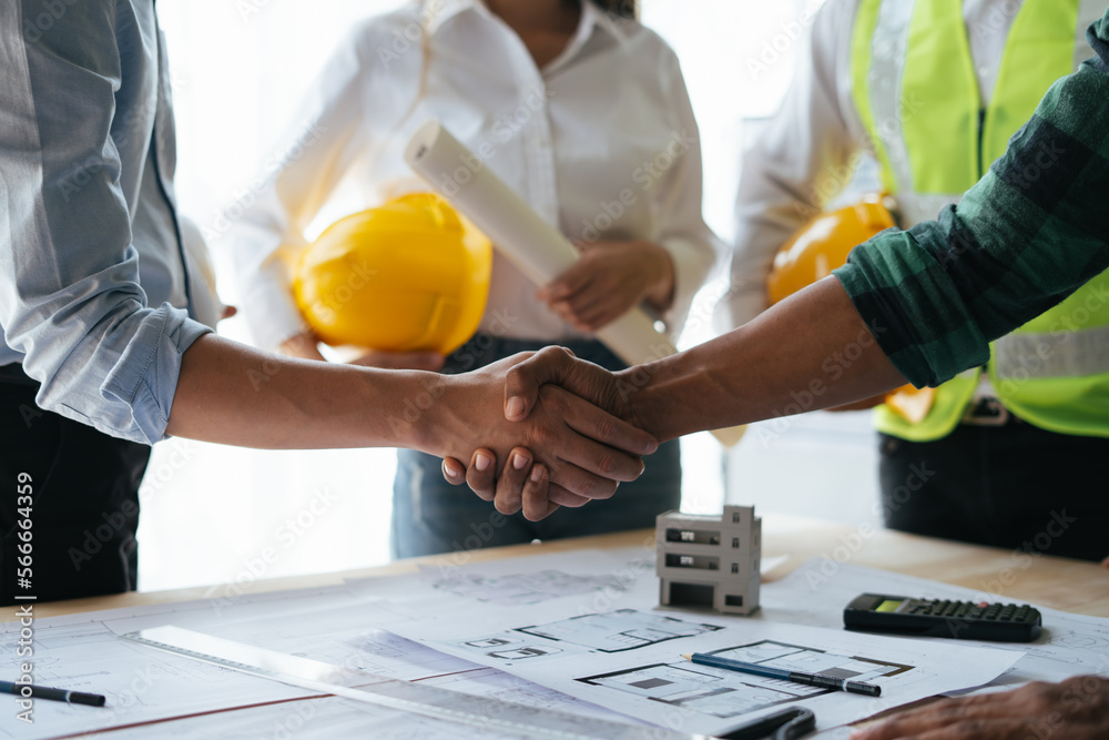Construction workers, architects and engineers shake hands after ...