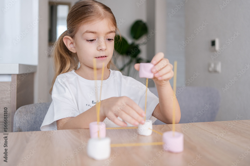 child girl playing and creating molecular shapes model from marshmallow ...