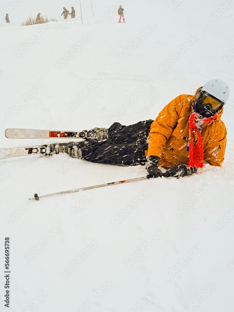 Foto de Fun on the slopes, male skier in brightly coloured jacket lies ...
