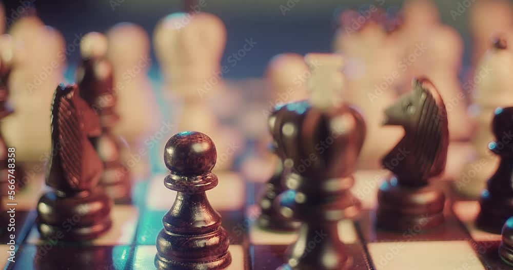 Chess game. Close-up view hand makes strategic move with figure on ...