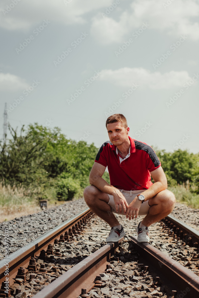 Young Male Model Posing in Red Polo Shirt on Train Tracks. Portrait ...