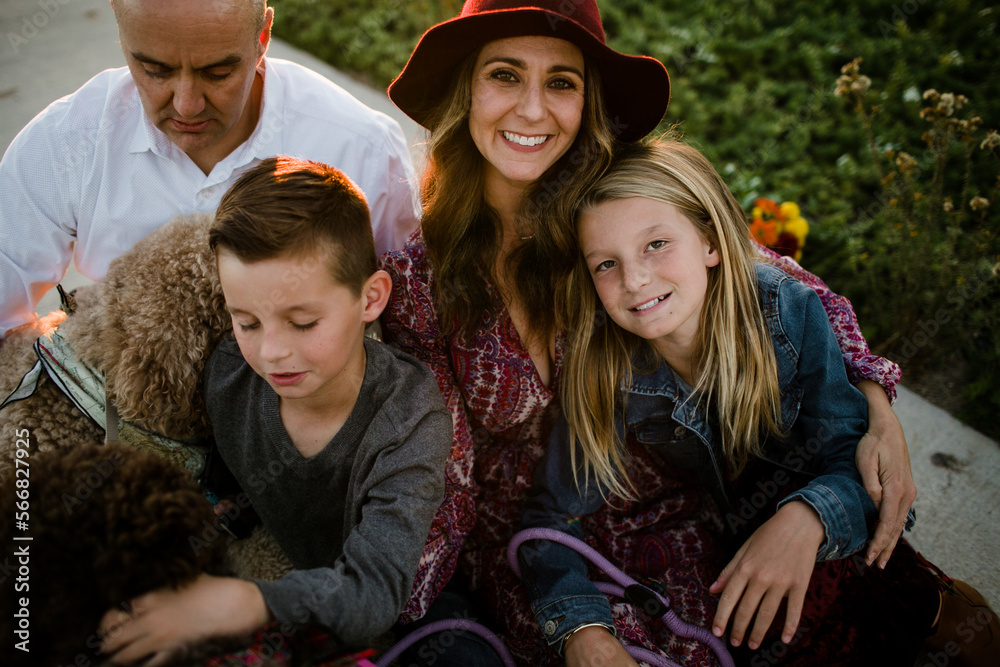 Family of four with dogs sitting together hugging and smiling in SoCal ...
