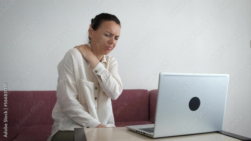 Freelancer with shoulder pain after computer work. A view of upset ...
