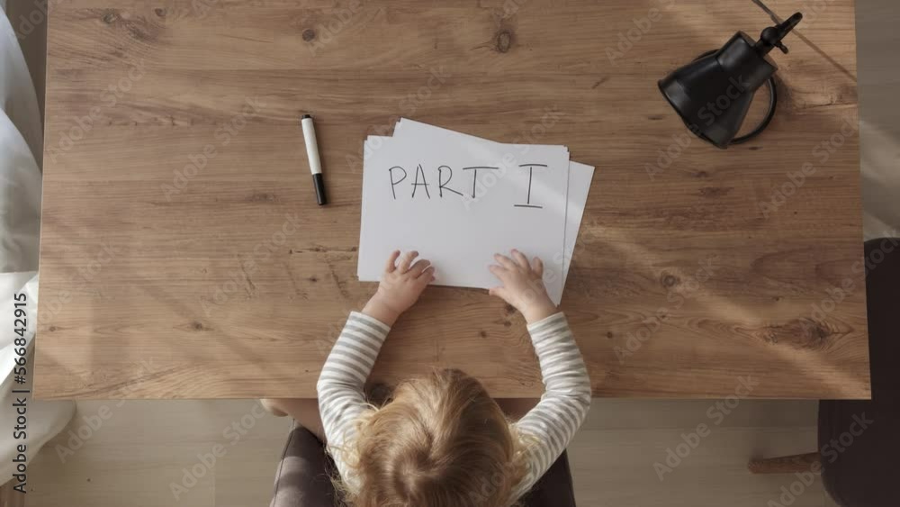 Vidéo Stock Top down view of child at table, who takes paper with ...