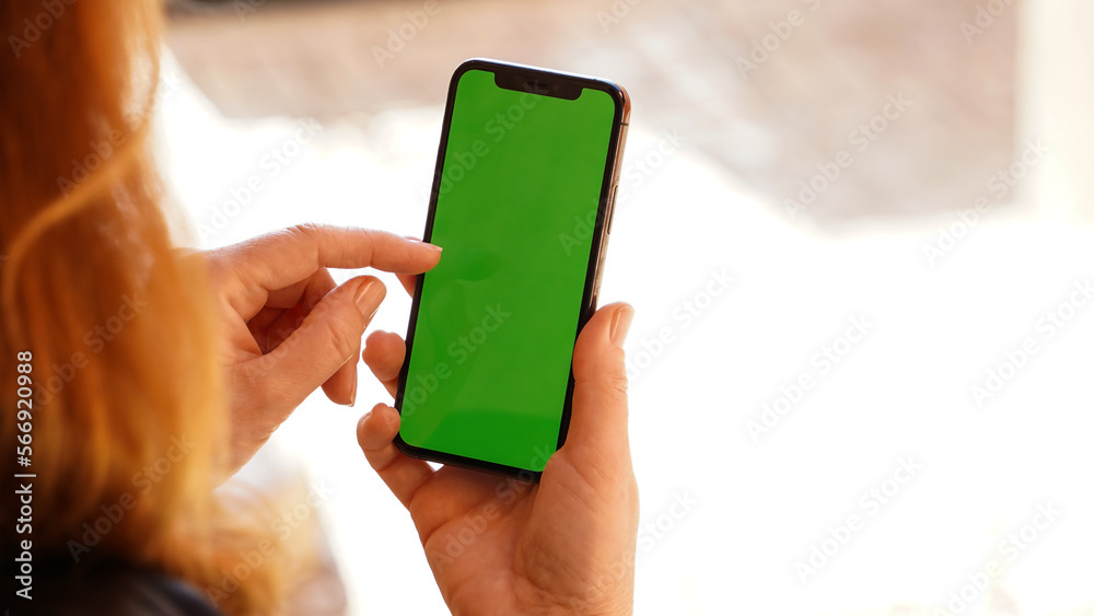 Female hands holding smartphone with green screen. Woman using mobile ...
