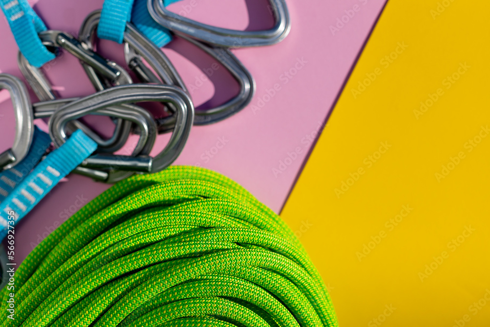 green rope and climbing and mountaineering equipment lies on a colored ...