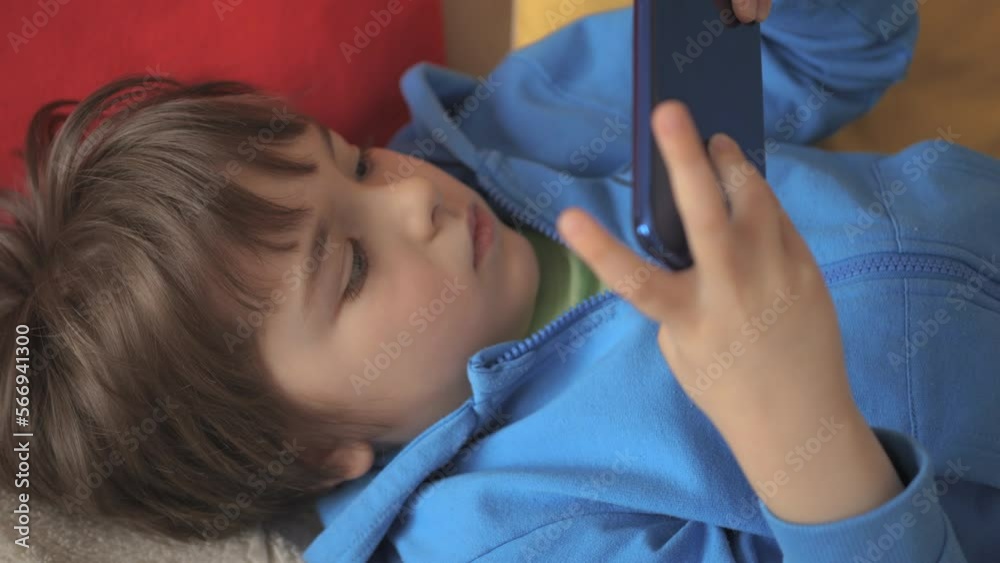 Vidéo Stock Child Playing Games In Phone at Home Lying on Couch. Boy Playing Video Game on ...