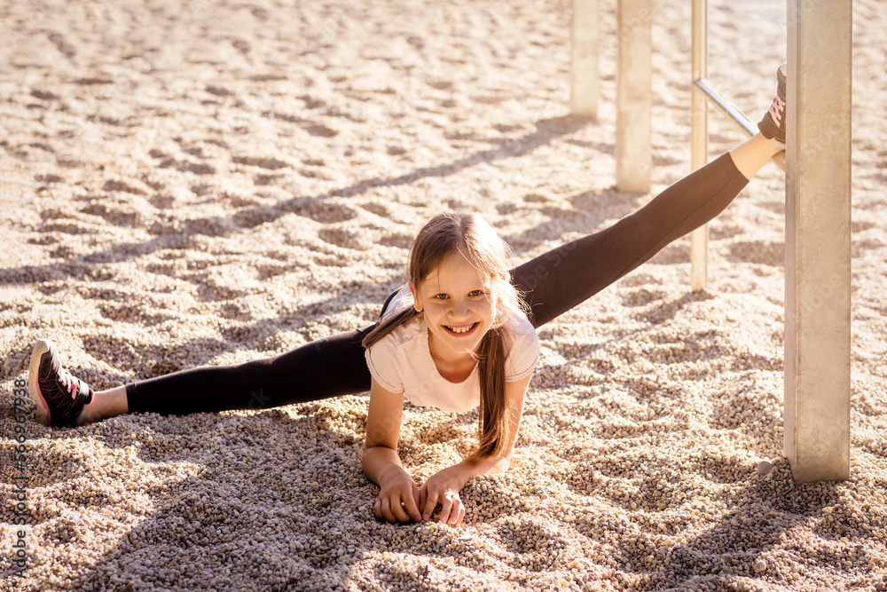 Foto de Sport Girl Teen doing split exercise on Sport Stadium. Funny ...