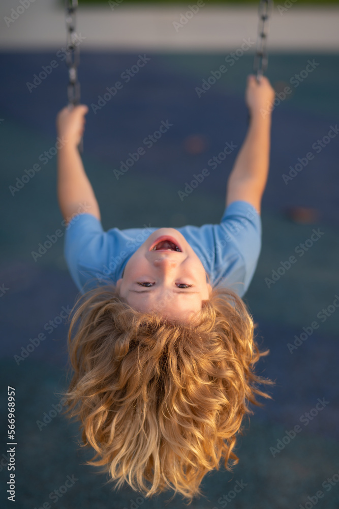 Funny child boy on swing. Kid swinging on playground. Cute excited amazed child on swing. Cute ...