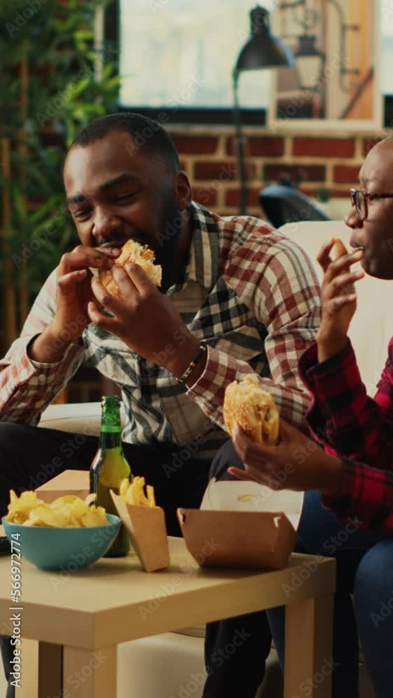 Vertical video: African american people eating burgers and fries ...