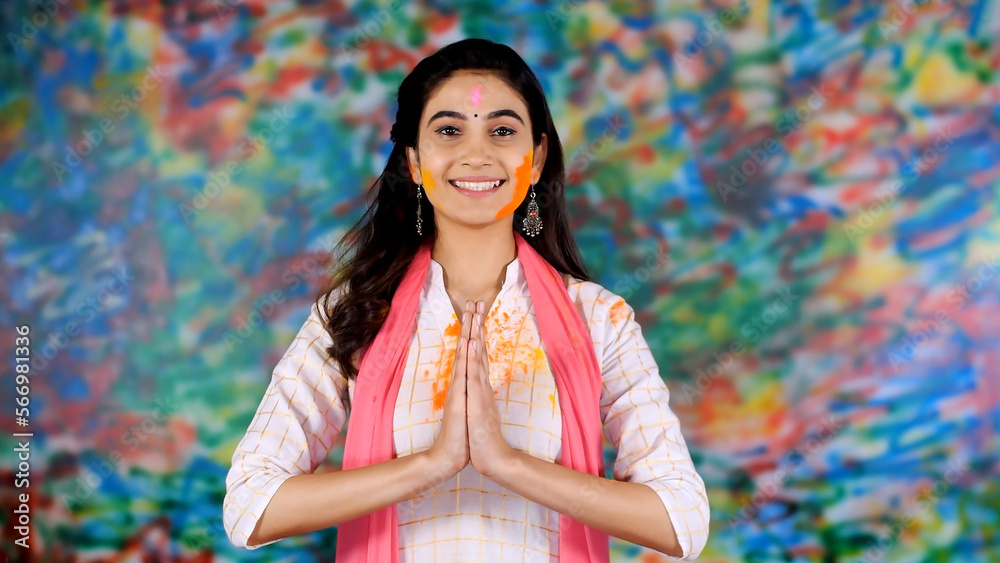 A beautiful woman with long hair greeting people on Holi with a ...