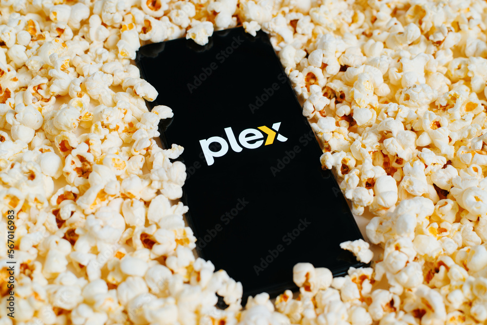 Plex stream movies TV shows is mobile application on screen of smartphone lying in pile of ...