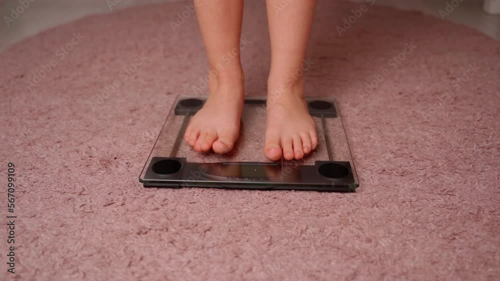 Girl gets off from scales in room close up slow motion. Young female ...
