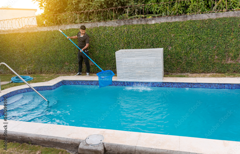 Maintenance person cleaning a swimming pool with skimmer, Worker ...
