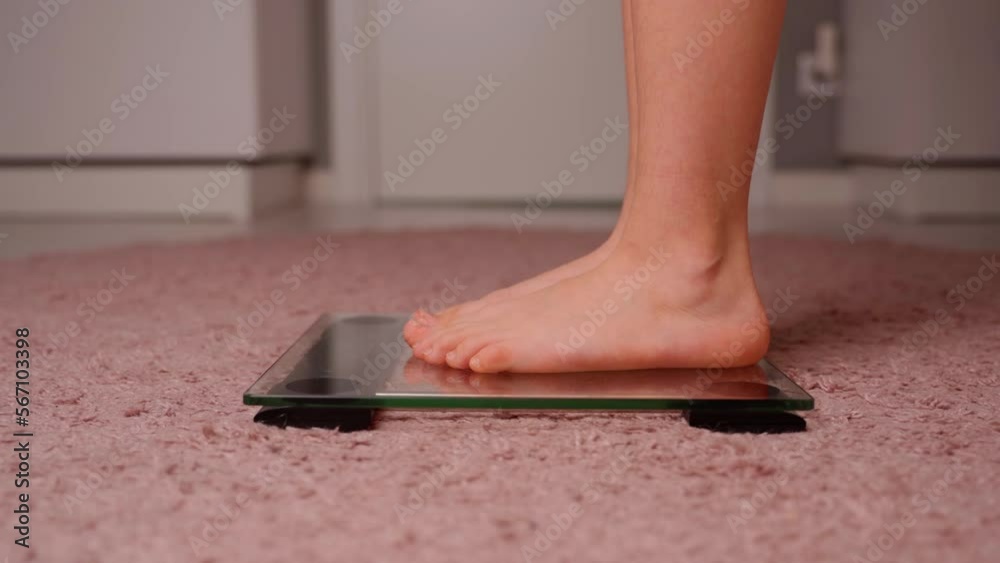Girls legs on the scales close-up. Young female person measure body ...