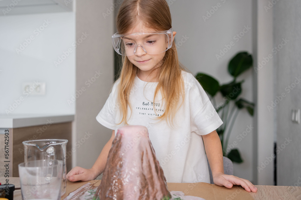 volcanic eruption. school science project. Kid girl watching a ...