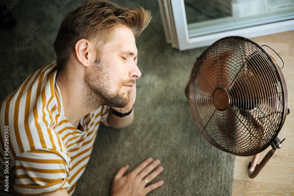 Heat wave during a summer, a man finds respite at his home balcony with ...