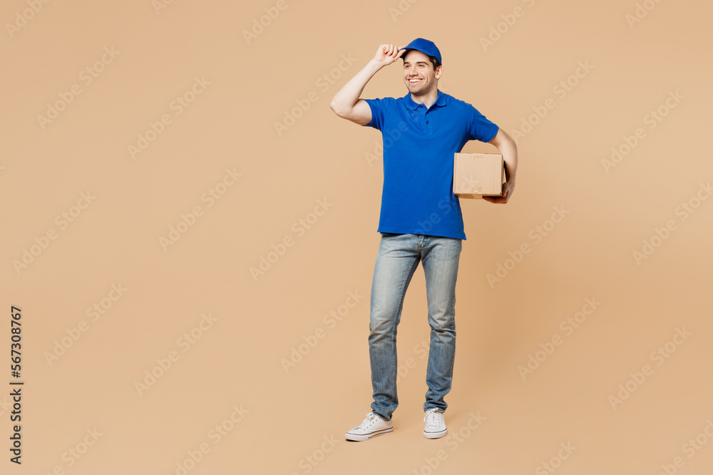 Full body fun delivery guy employee man wear blue cap t-shirt uniform ...