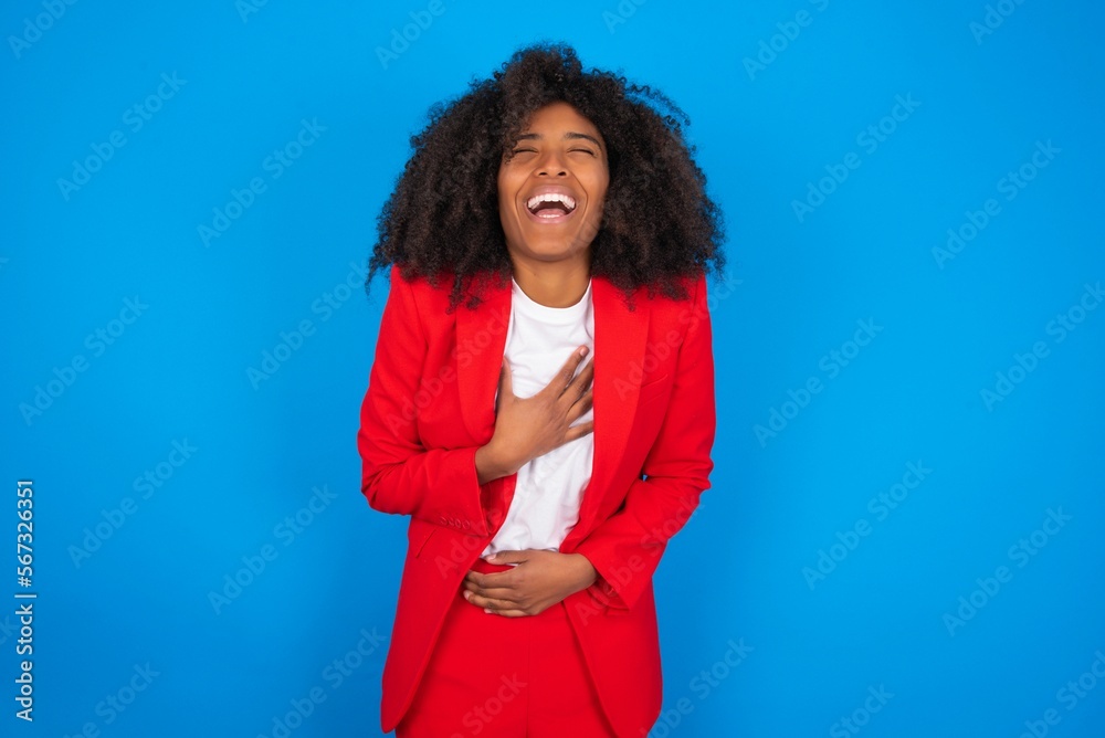 young businesswoman with afro hairstyle wearing red over blue ...