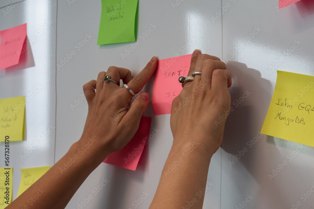 Des mains qui posent des post-it au tableau Stock Photo | Adobe Stock