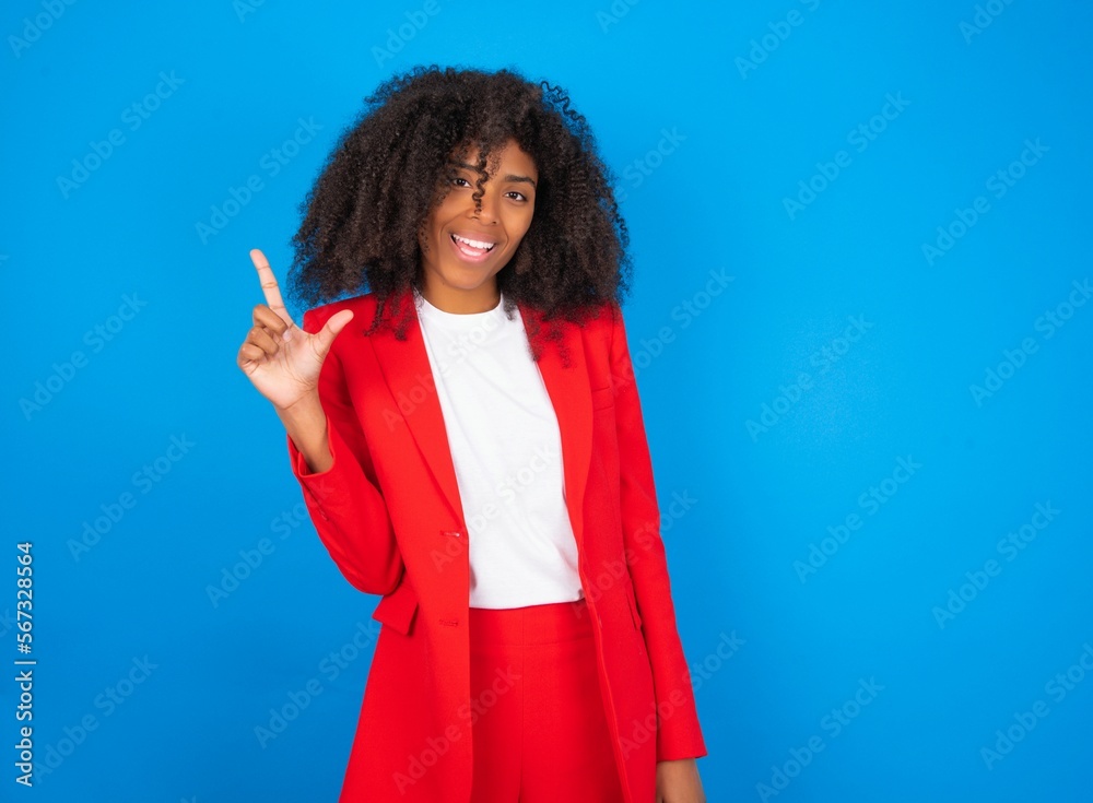 Pleasant looking young businesswoman with afro hairstyle wearing red ...