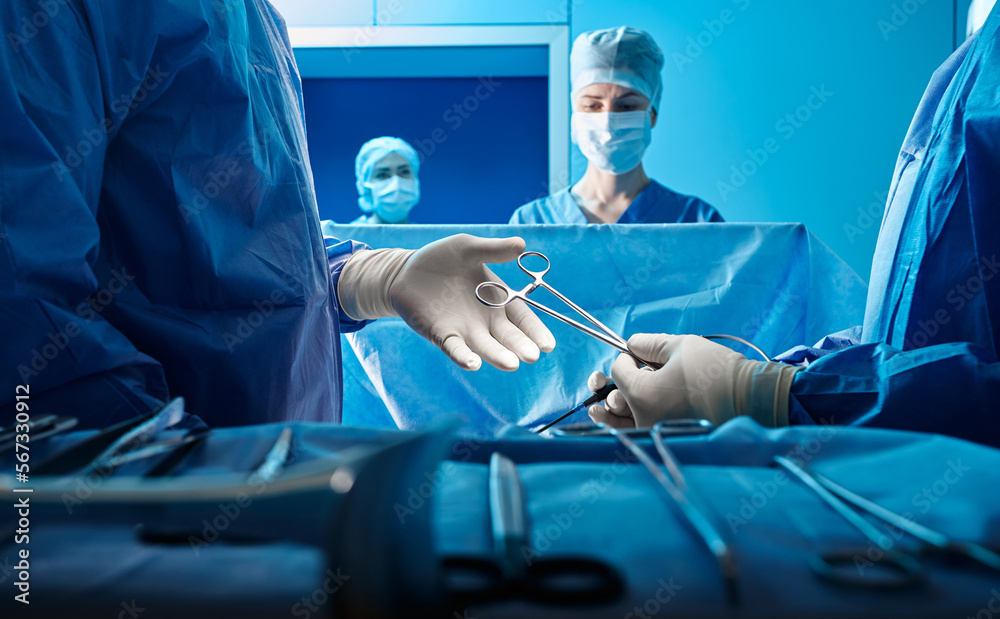 Surgeons performing surgical procedure on patient with surgical ...