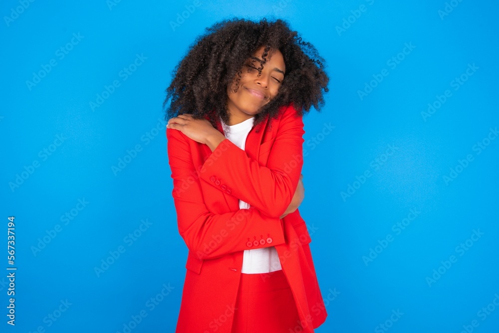 young businesswoman with afro hairstyle wearing red over blue ...