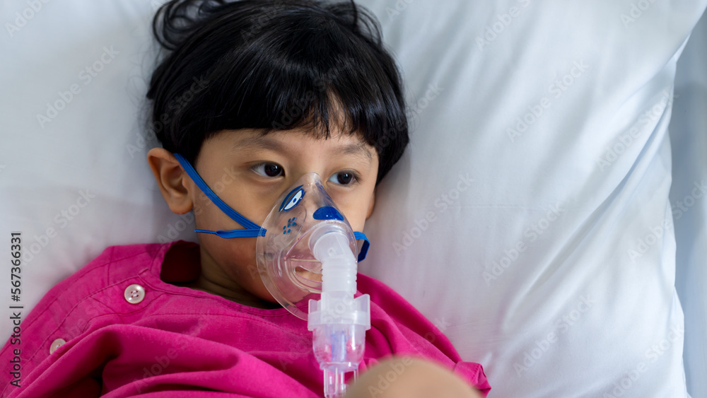 Sick boy inhalation therapy by the mask of inhaler. Baby has asthma and ...