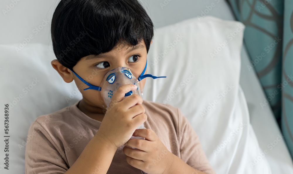 Sick boy inhalation therapy by the mask of inhaler. Baby has asthma and ...