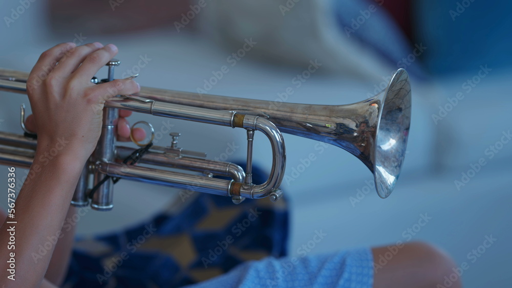 One young boy playing trumpet. Preteen male kid practicing musical ...
