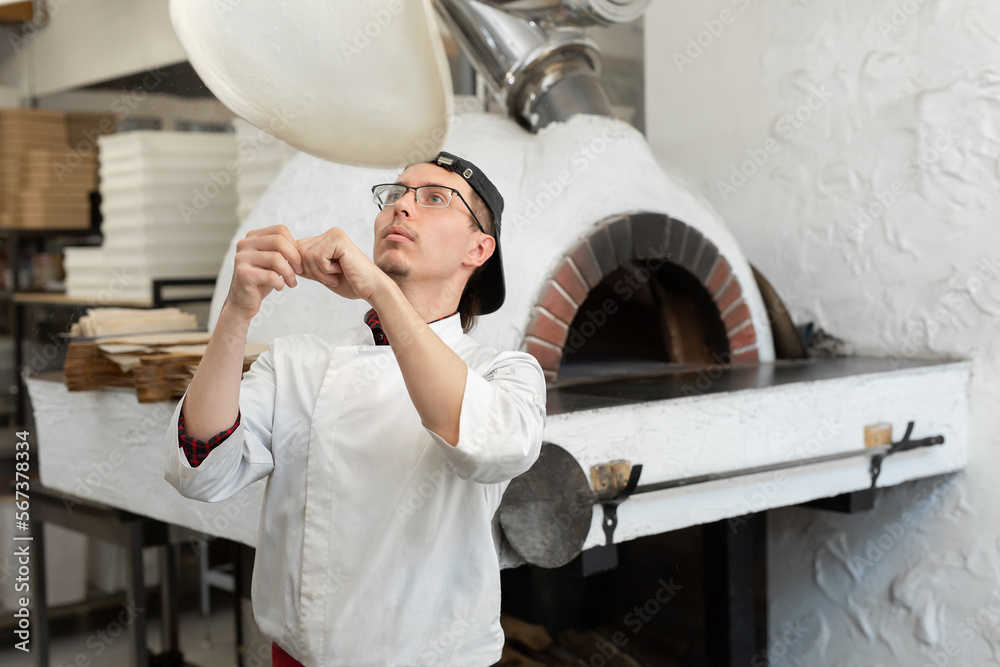 Pizza Chef makes the pizza dough spin in the air to make it thin and ...