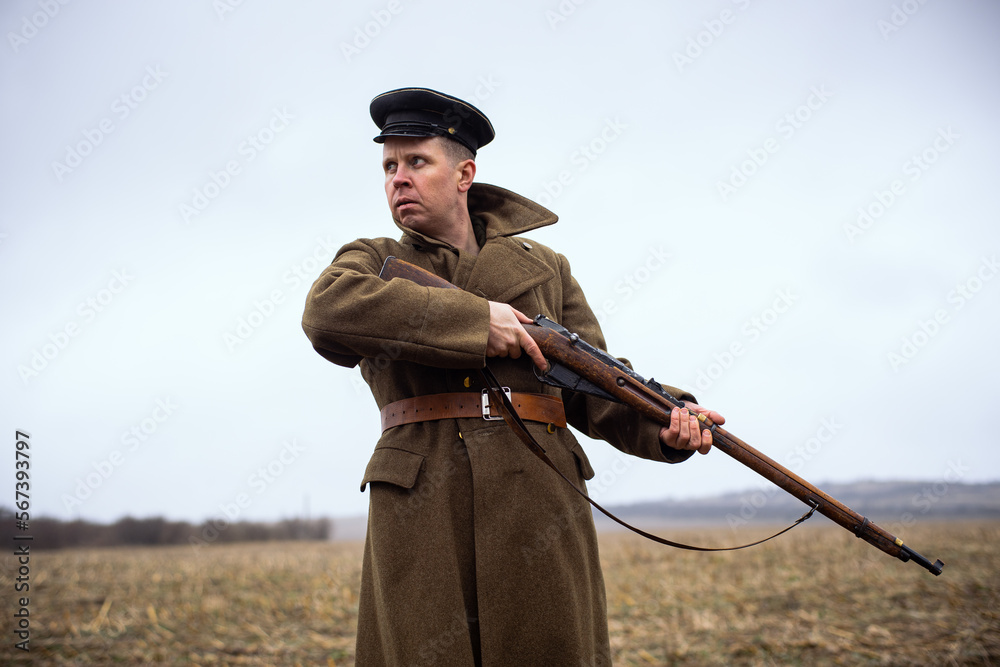 retro soldier holding a weapon and standing in a field. World War I ...