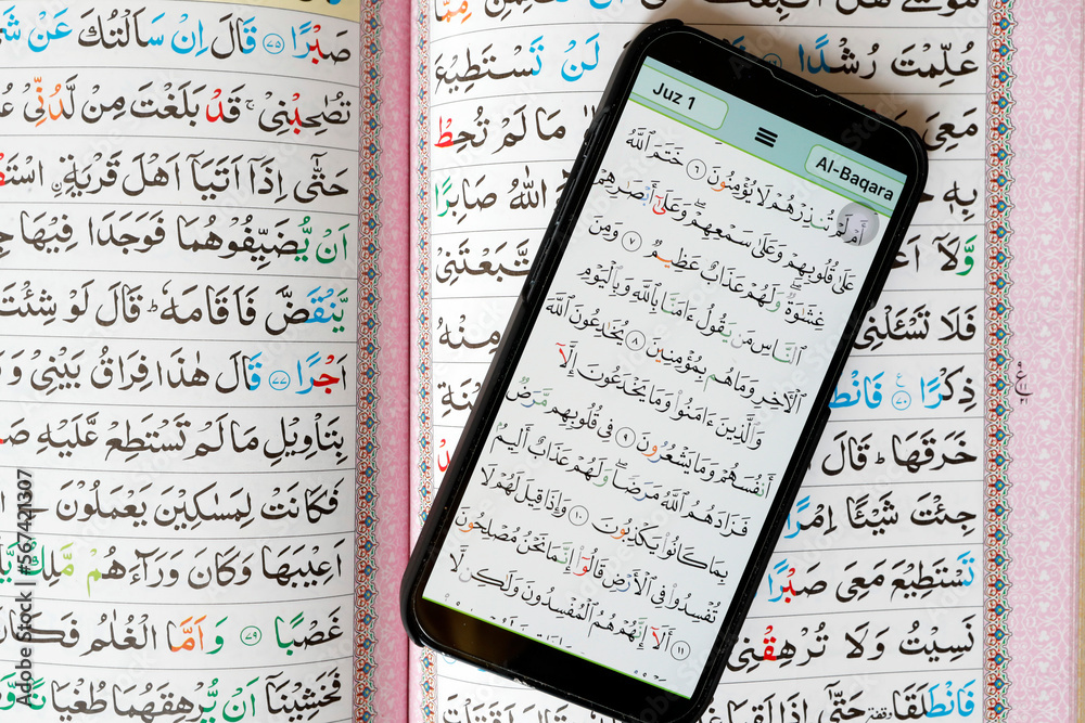 Digital Quran on smartphone and traditional paper Holy Quran, paper and digital Quran, Al-Serkal ...