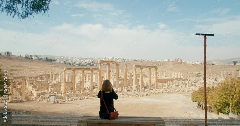 Young lady snapping pictures by analogue camera of ancient ruins ...