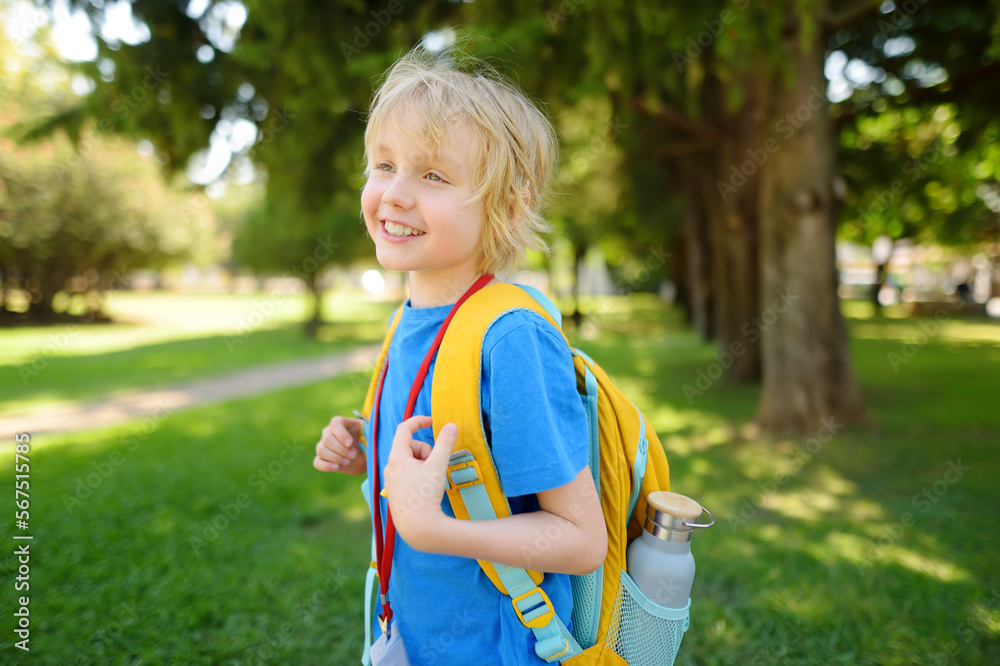 Elementary boy with backpack, bottle of water and name badge on his ...