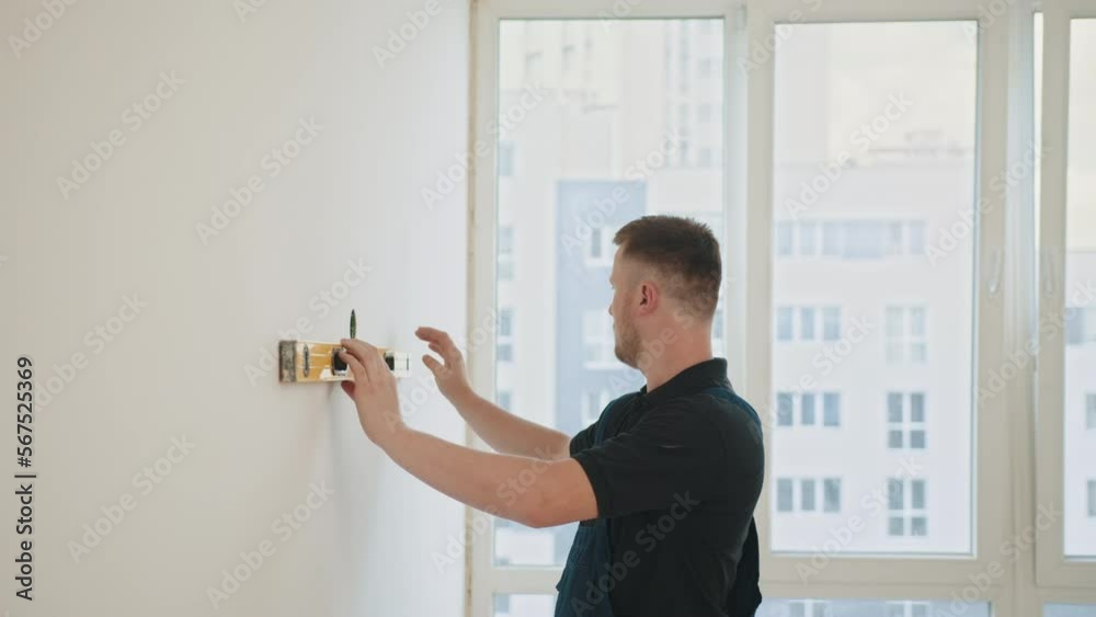 Construction builder working with water level tool to do measurement ...